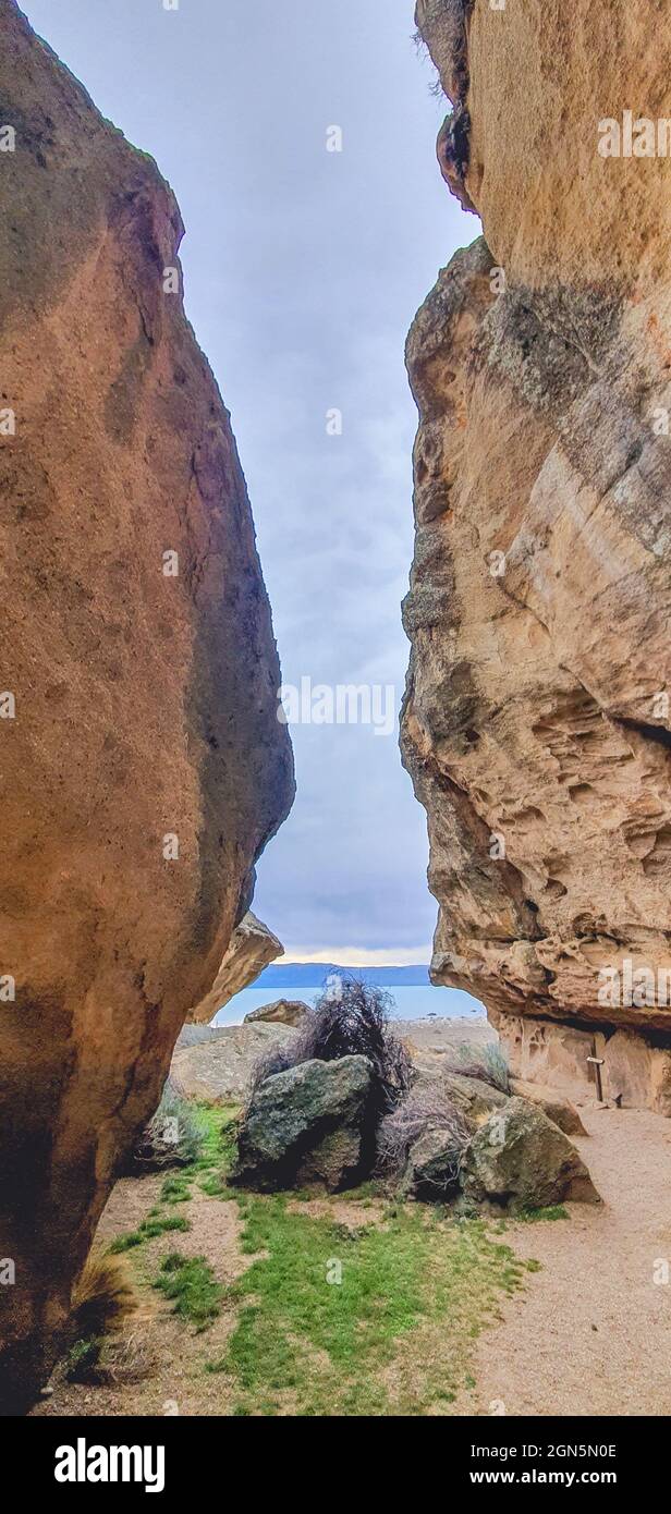 Vertical shot of the seascape and skyline through two big cliffs on the ...