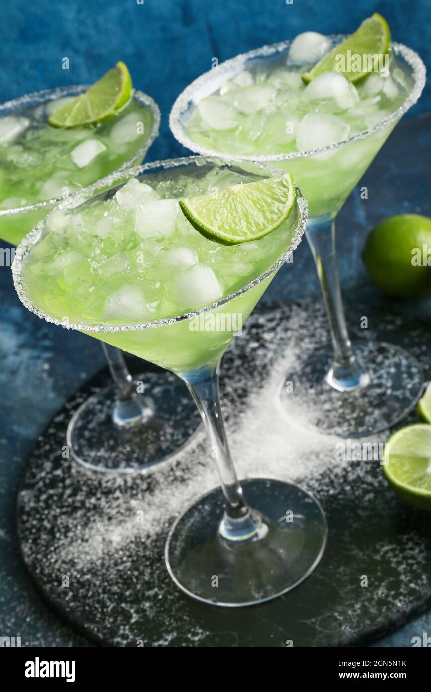 Slate plate with glasses of tasty daiquiri cocktail on color background ...