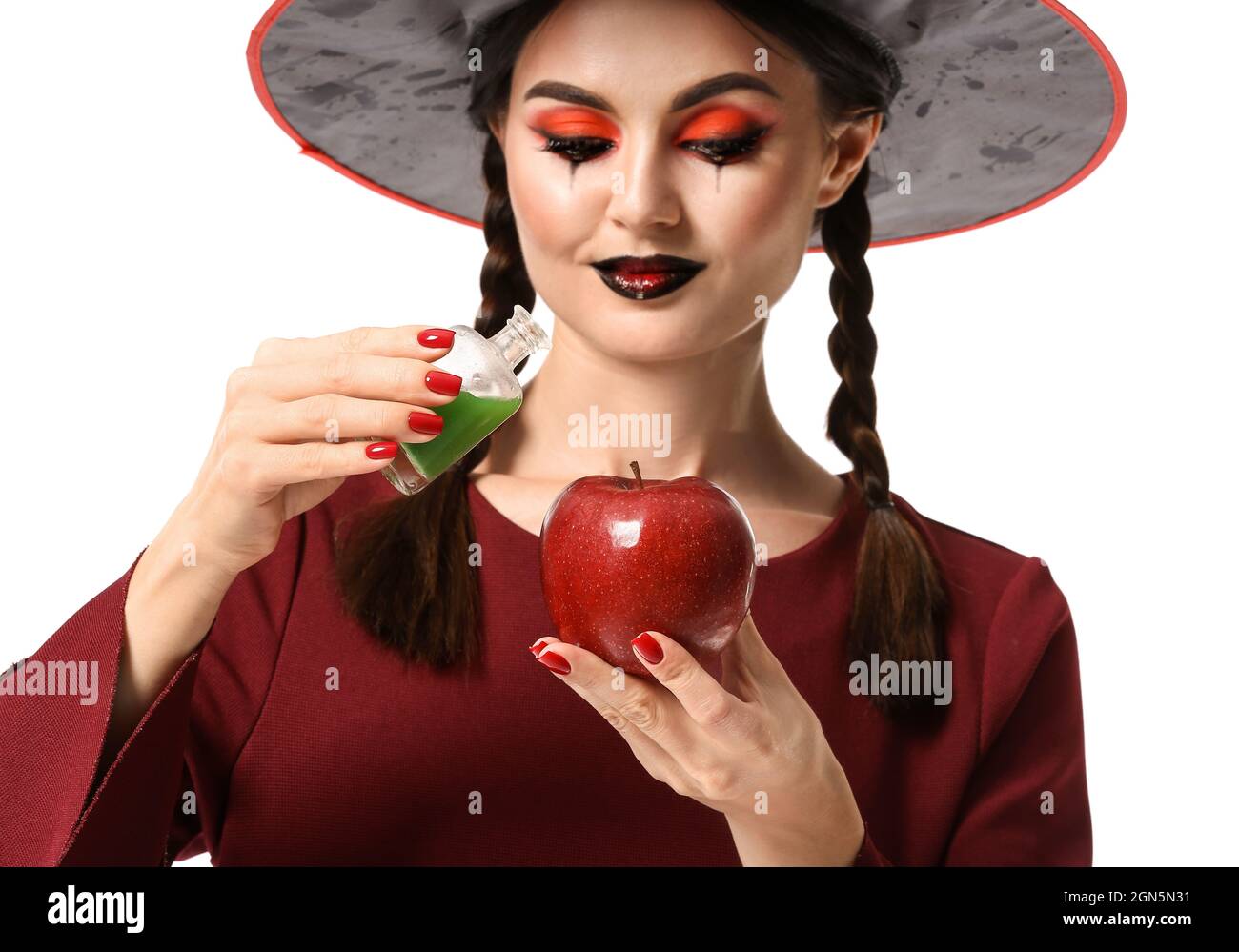 Young witch with potion and apple on white background Stock Photo - Alamy