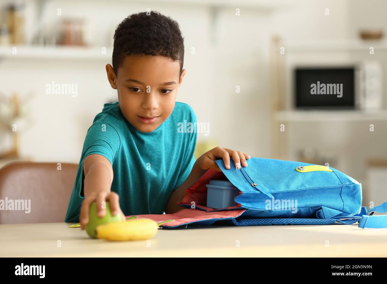 Cute little boy putting his school lunch in bag Stock Photo - Alamy