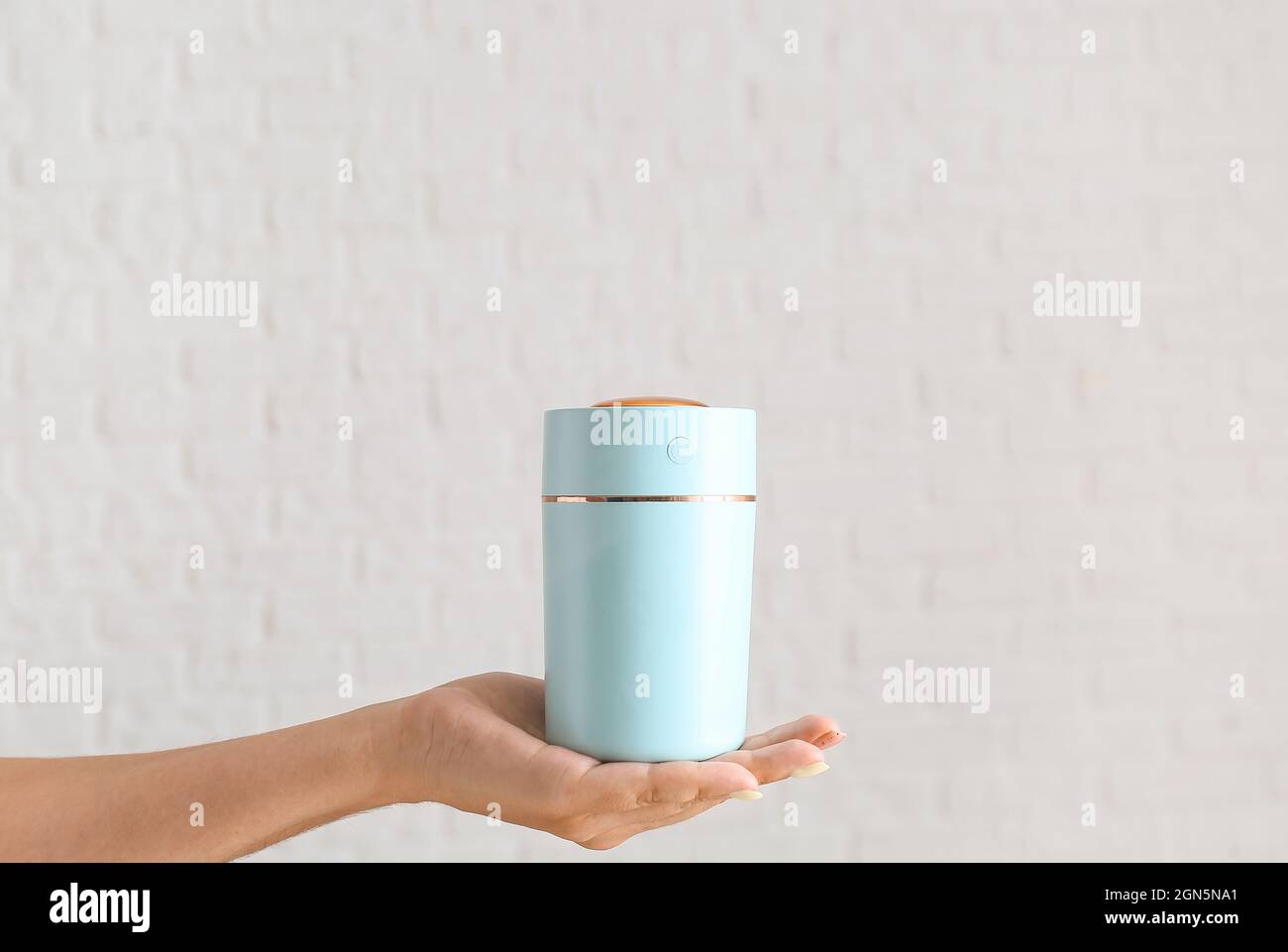 Hand with modern air humidifier on light background Stock Photo - Alamy