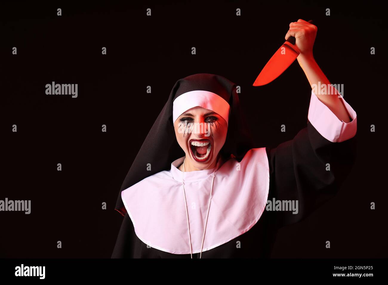 Woman dressed for Halloween as nun with knife on dark background Stock ...