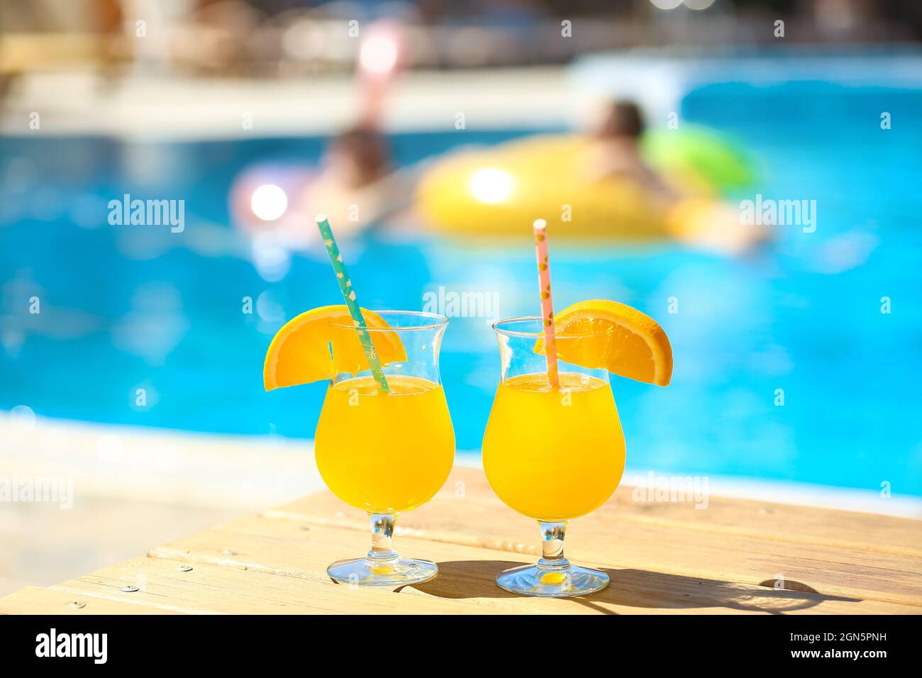 Glasses of cocktails on table near swimming pool Stock Photo - Alamy