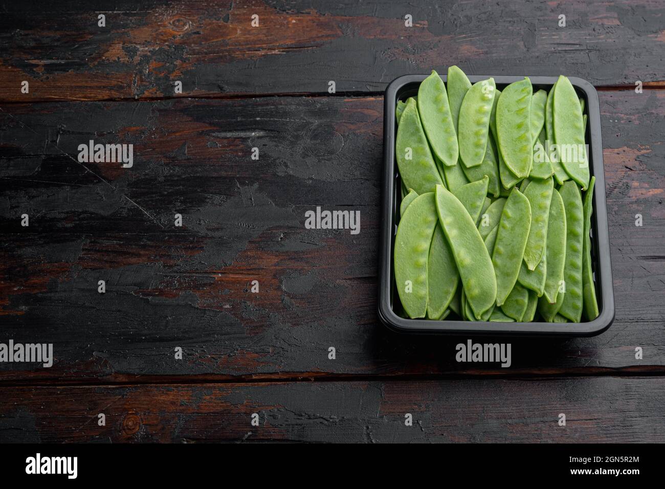 Sugar snap peas, raw ripe baby pods set, in plastic container, on old ...