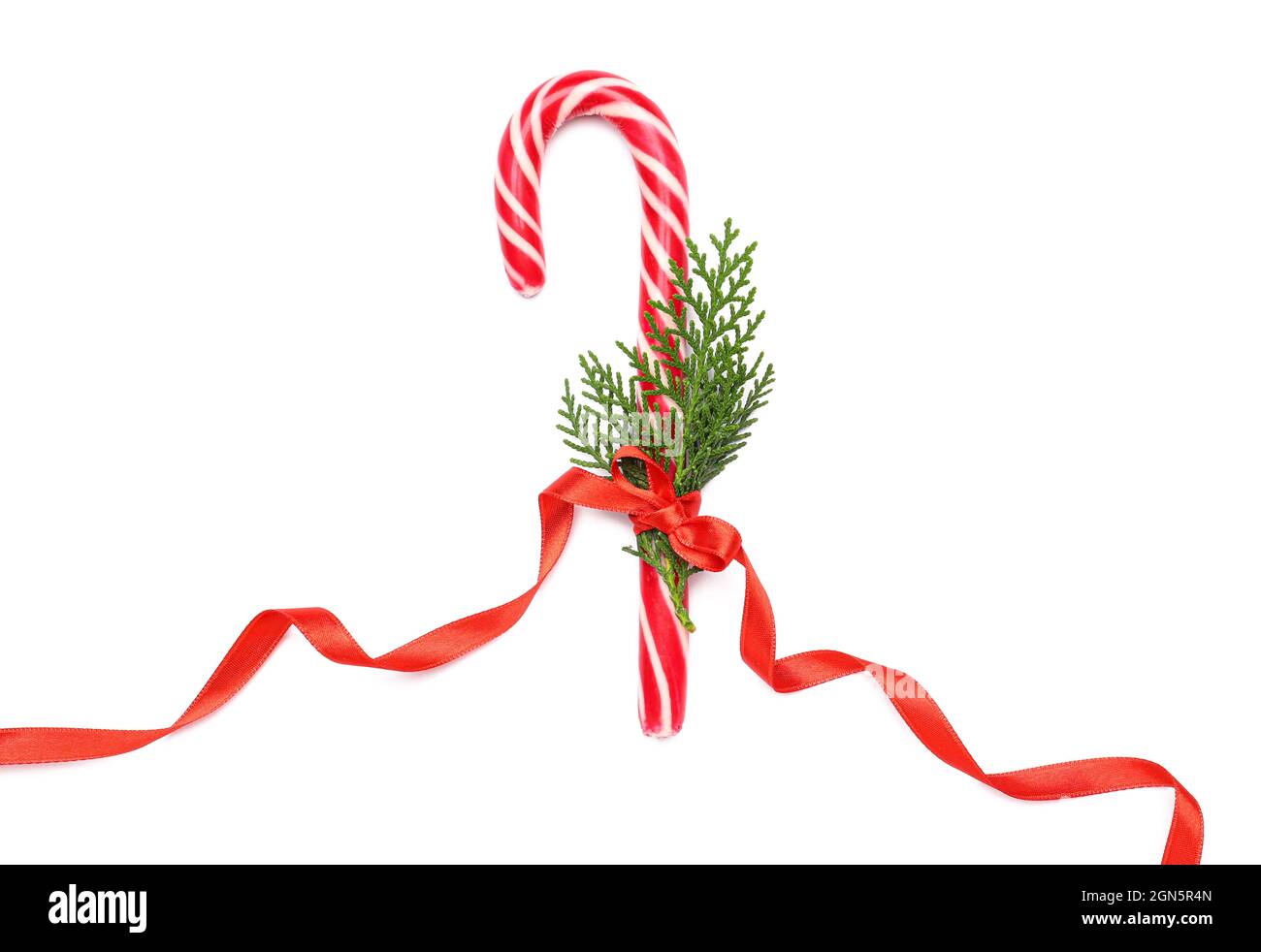 Tasty candy cane, ribbon and fir branch on white background Stock Photo ...