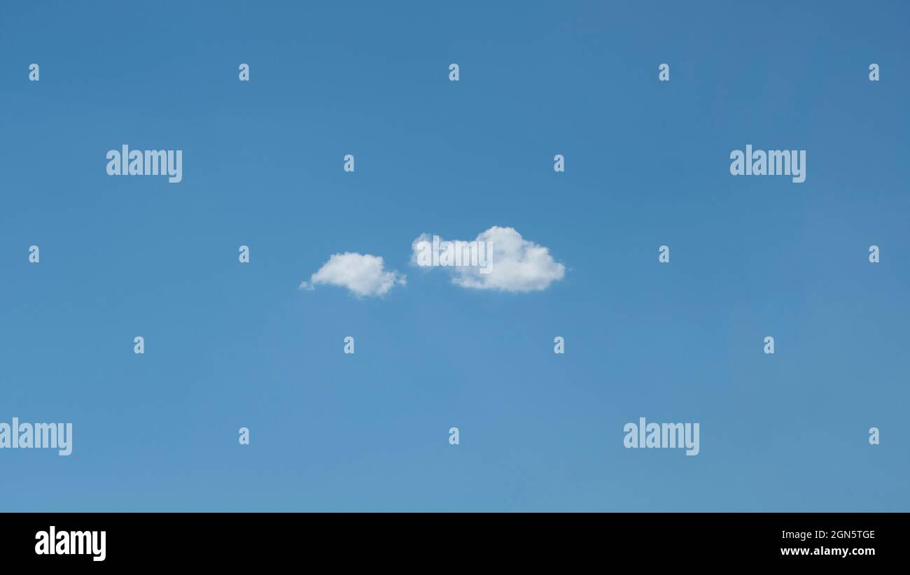 Only two clouds in a blue sky. Great for background use Stock Photo - Alamy