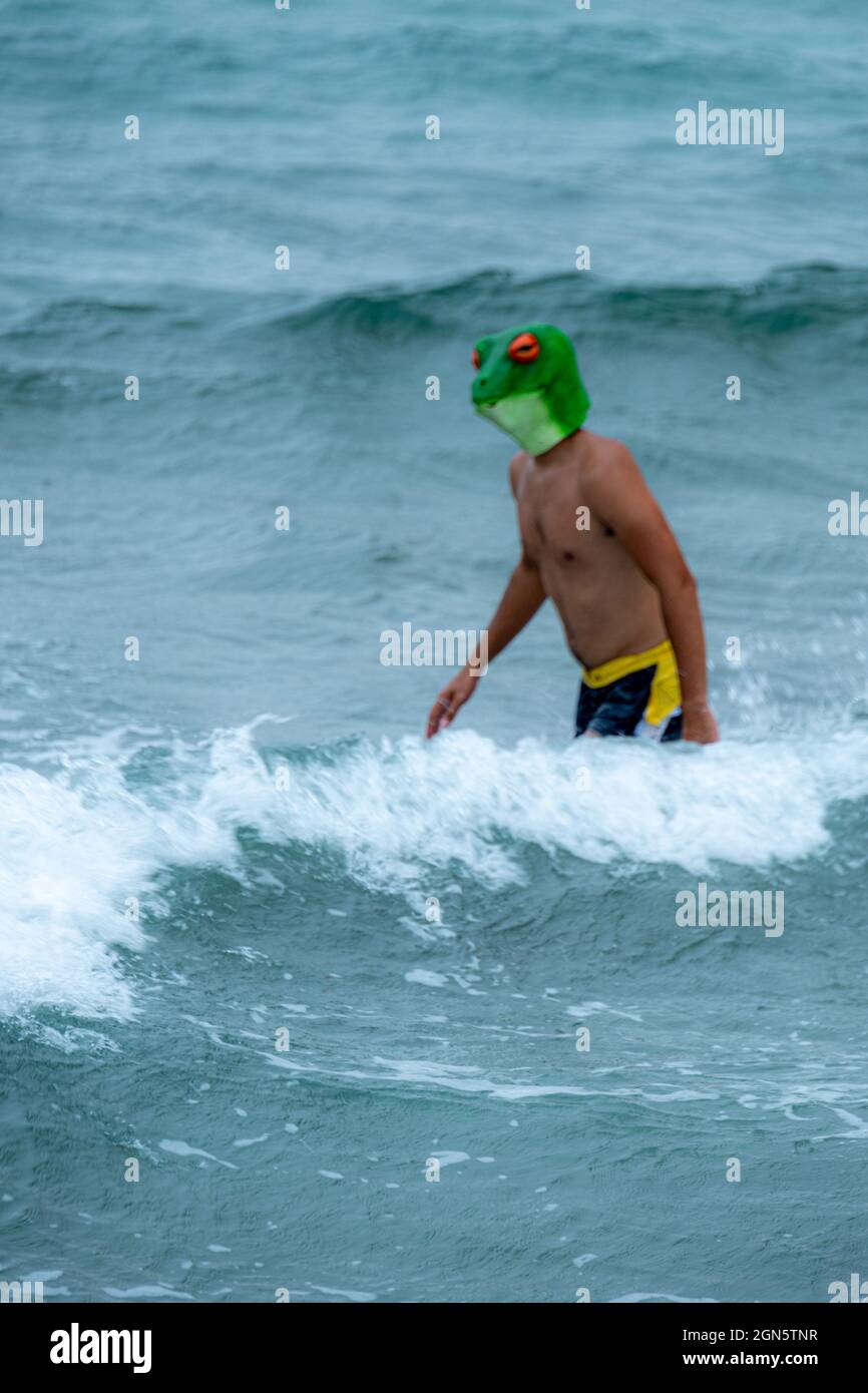 young man with frog mask on his head in the sea and waves Stock Photo ...