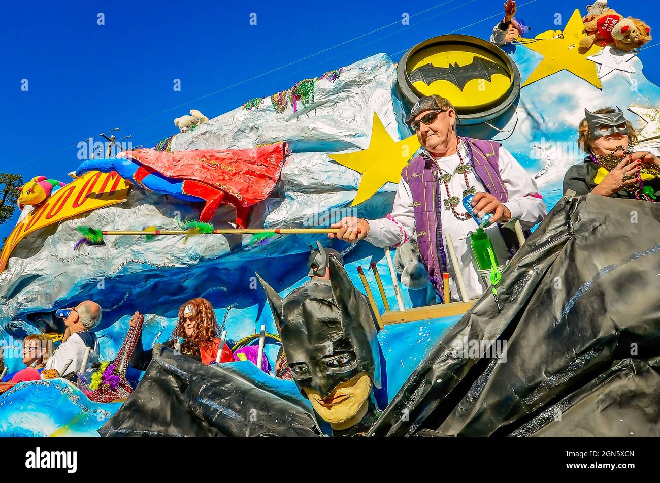 A Mardi Gras float with a superhero theme makes its way down the street ...