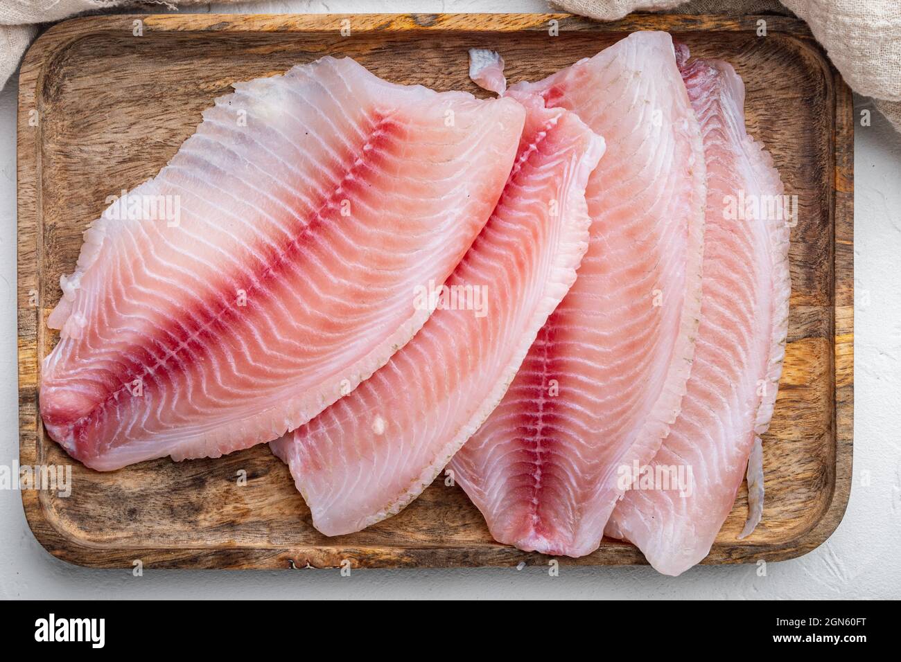 Raw tilapia fish fillet meat cuts, on white background, top view Stock ...