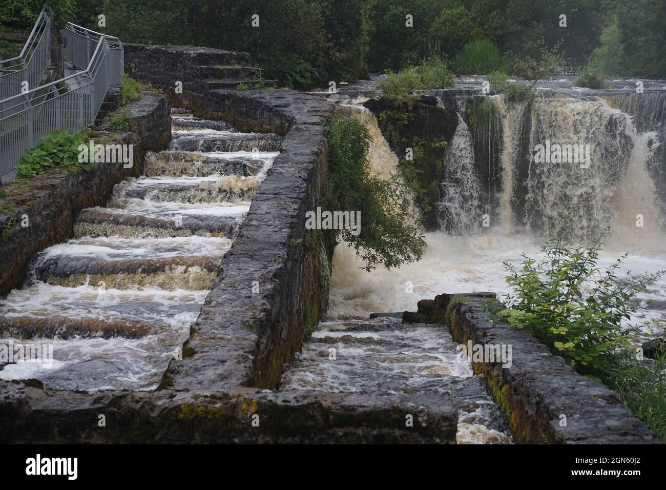 Raging water of a waterfalls running through steps going into a stream ...
