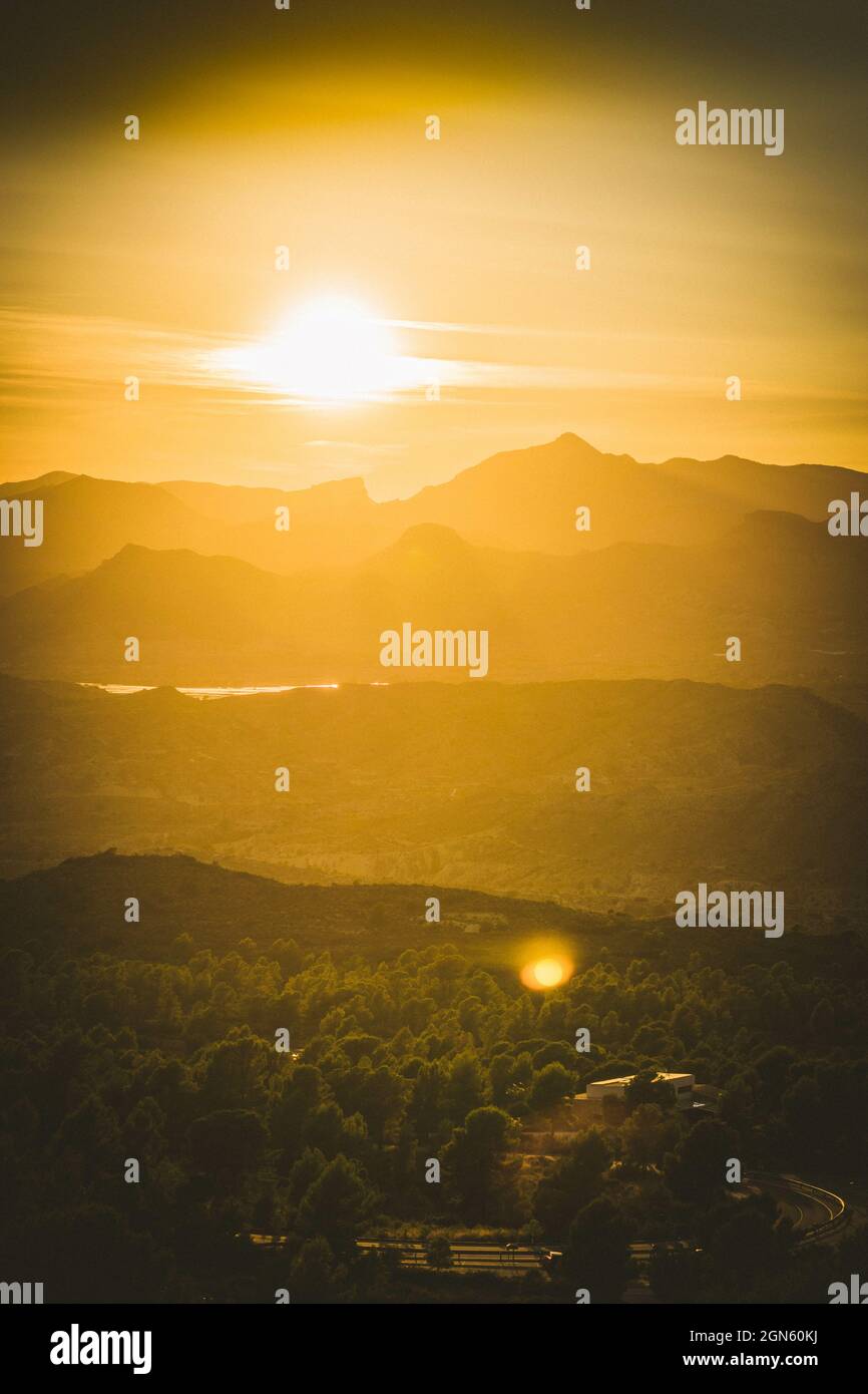 Breathtaking view of the bright, golden sun above mountain silhouettes ...