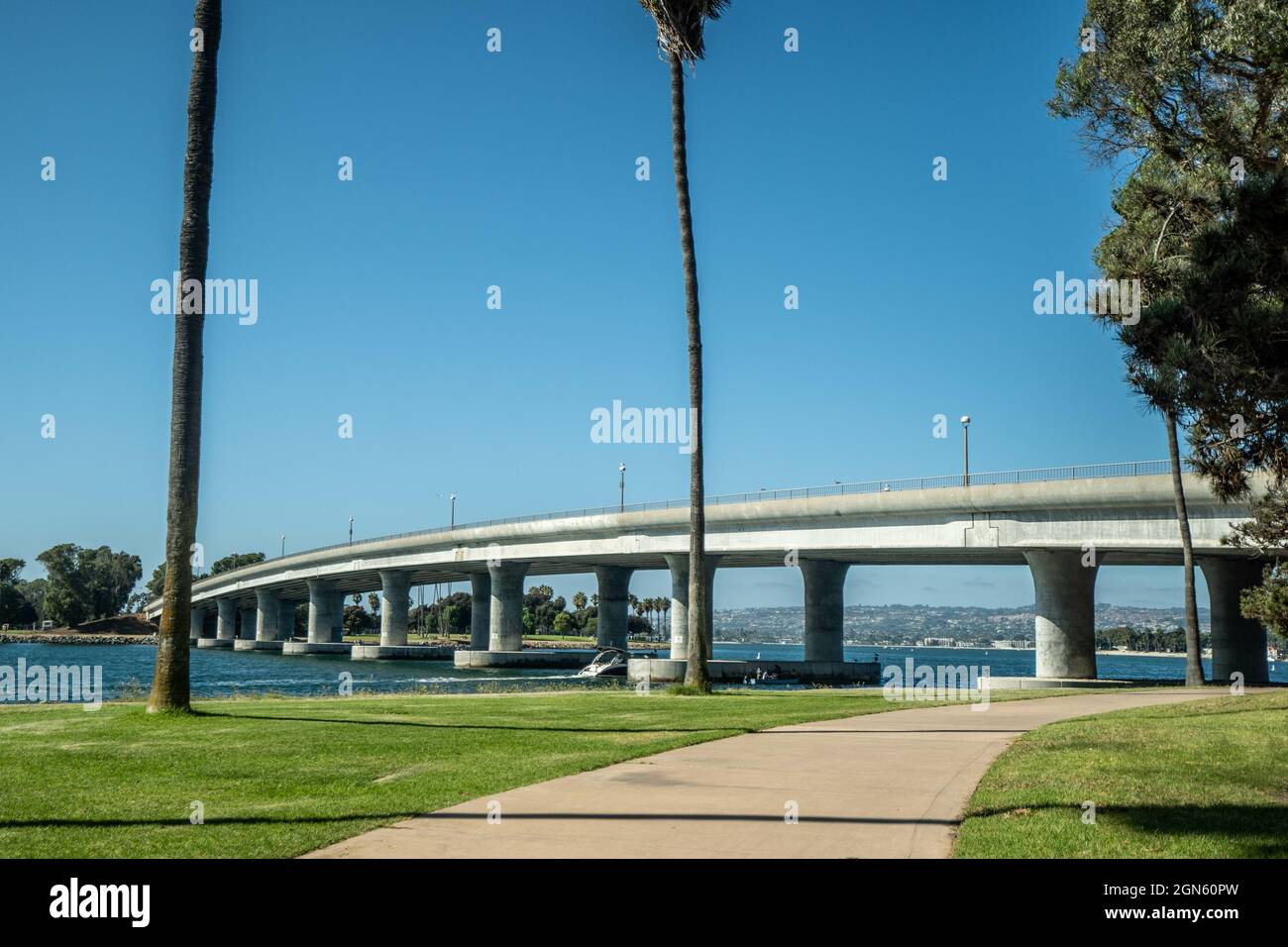 Long curved concrete bridge over a river under a clear blue sky Stock ...
