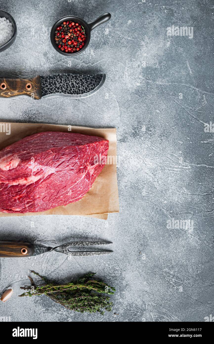 Round beef meat raw set with old butcher cleaver knife, on gray ...