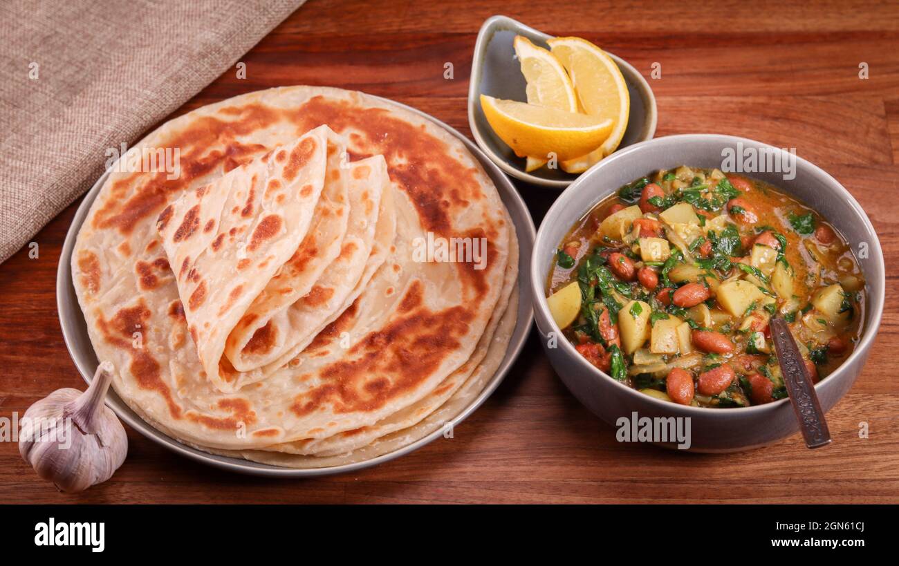 African chapati and bean stew served with garlic and lemons Stock Photo ...