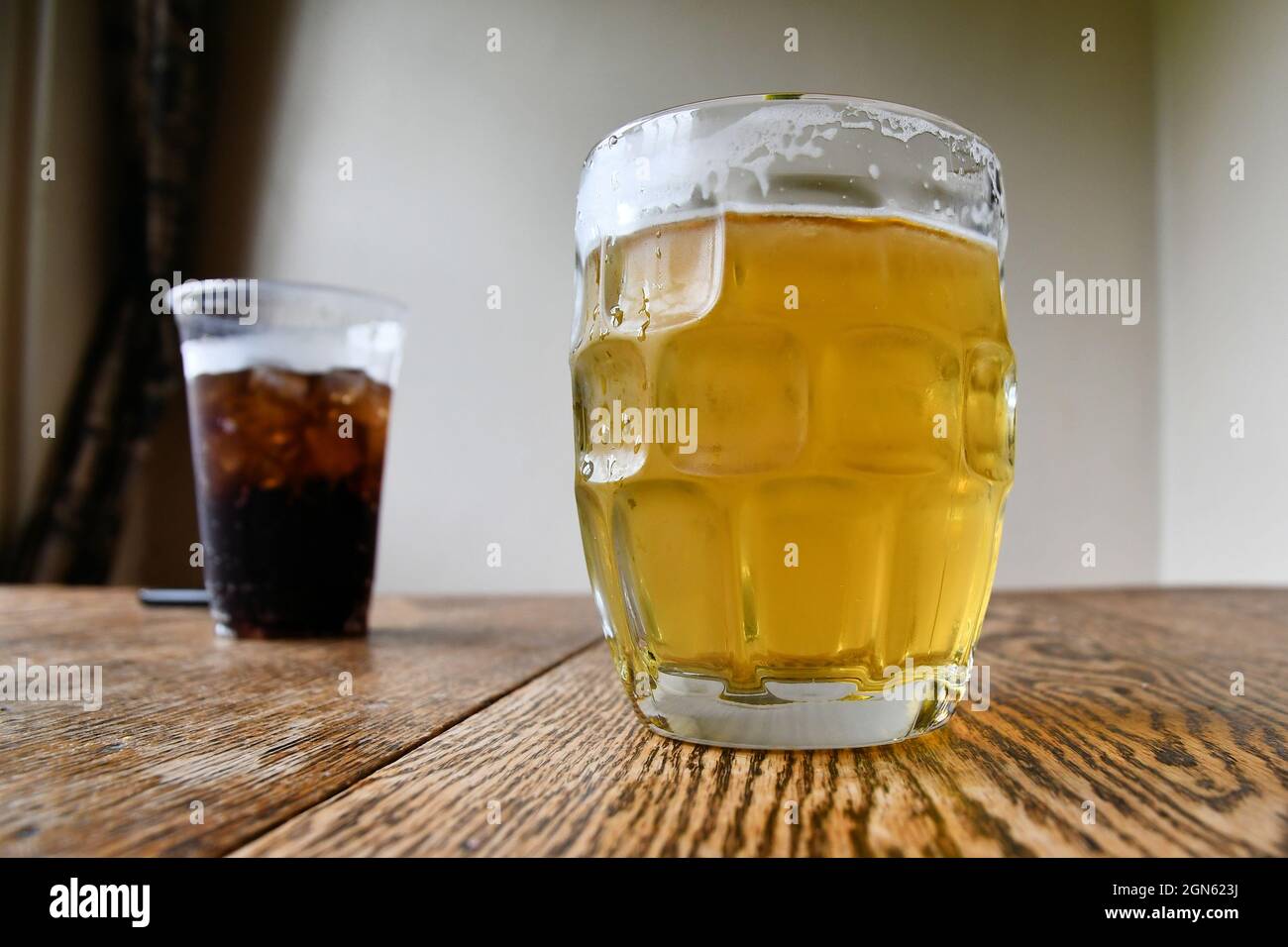 Beer mug with full of draft beer on a rustic dinner table with a glass ...