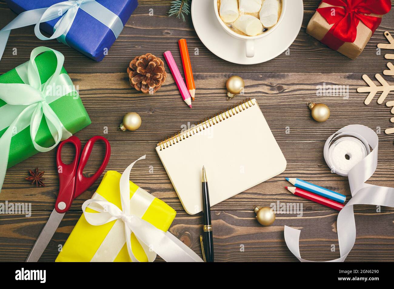 Writing christmas greeting cards. Open notepad with pen on decorated ...