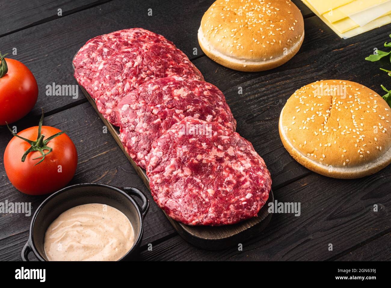 Ground Beef Patties for Grilling and Roasting set, on black wooden ...