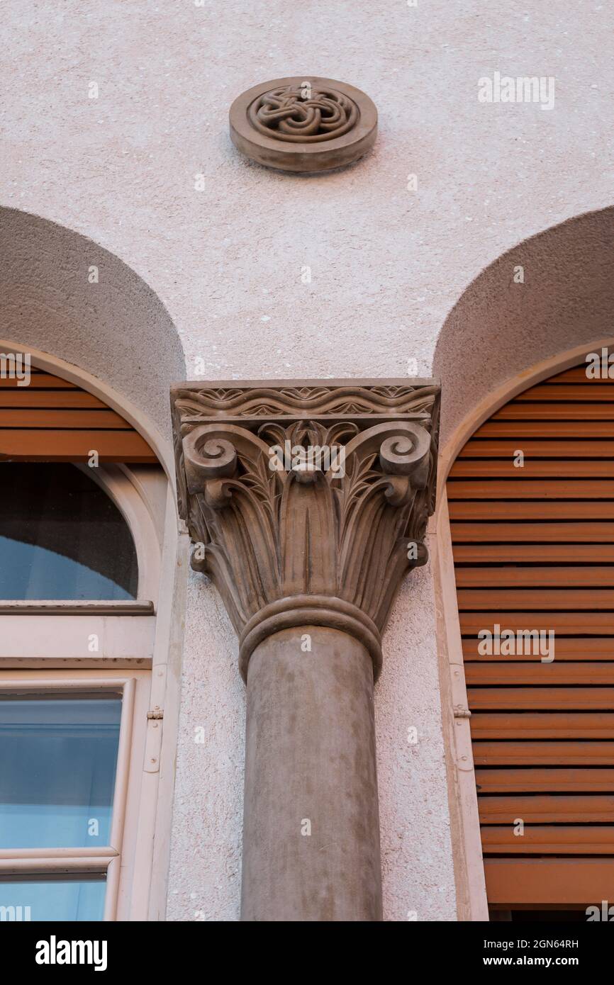 Low angle of the exterior of a building with a pillar with carvings ...