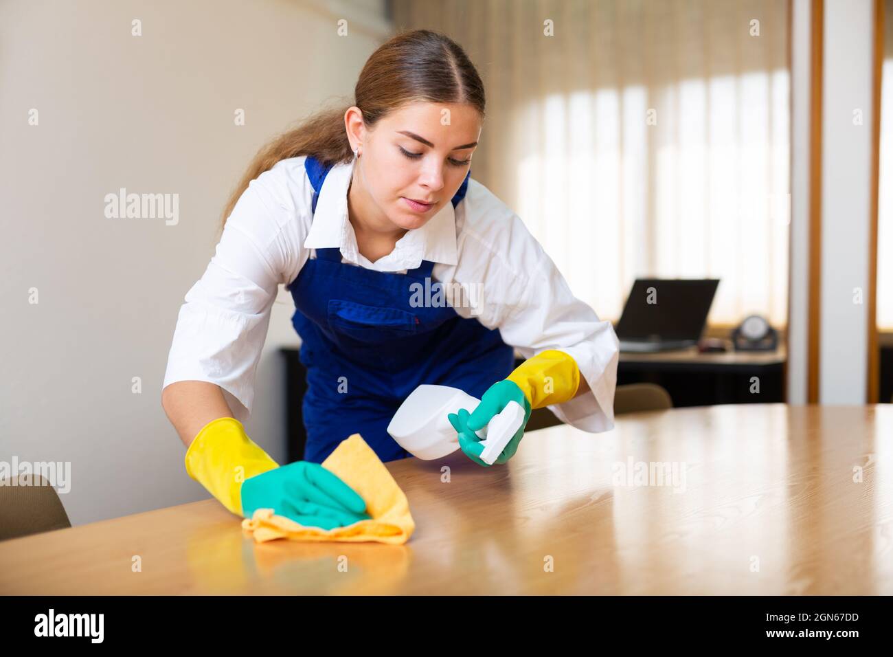 Portrait of a young female worker cleaning an office desk Stock Photo ...