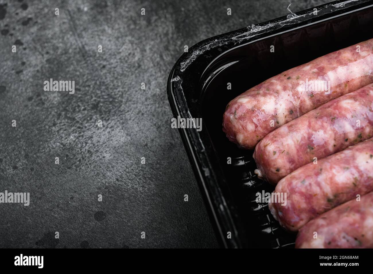 Flesh meat product for cooking packed in box set, on black dark stone ...