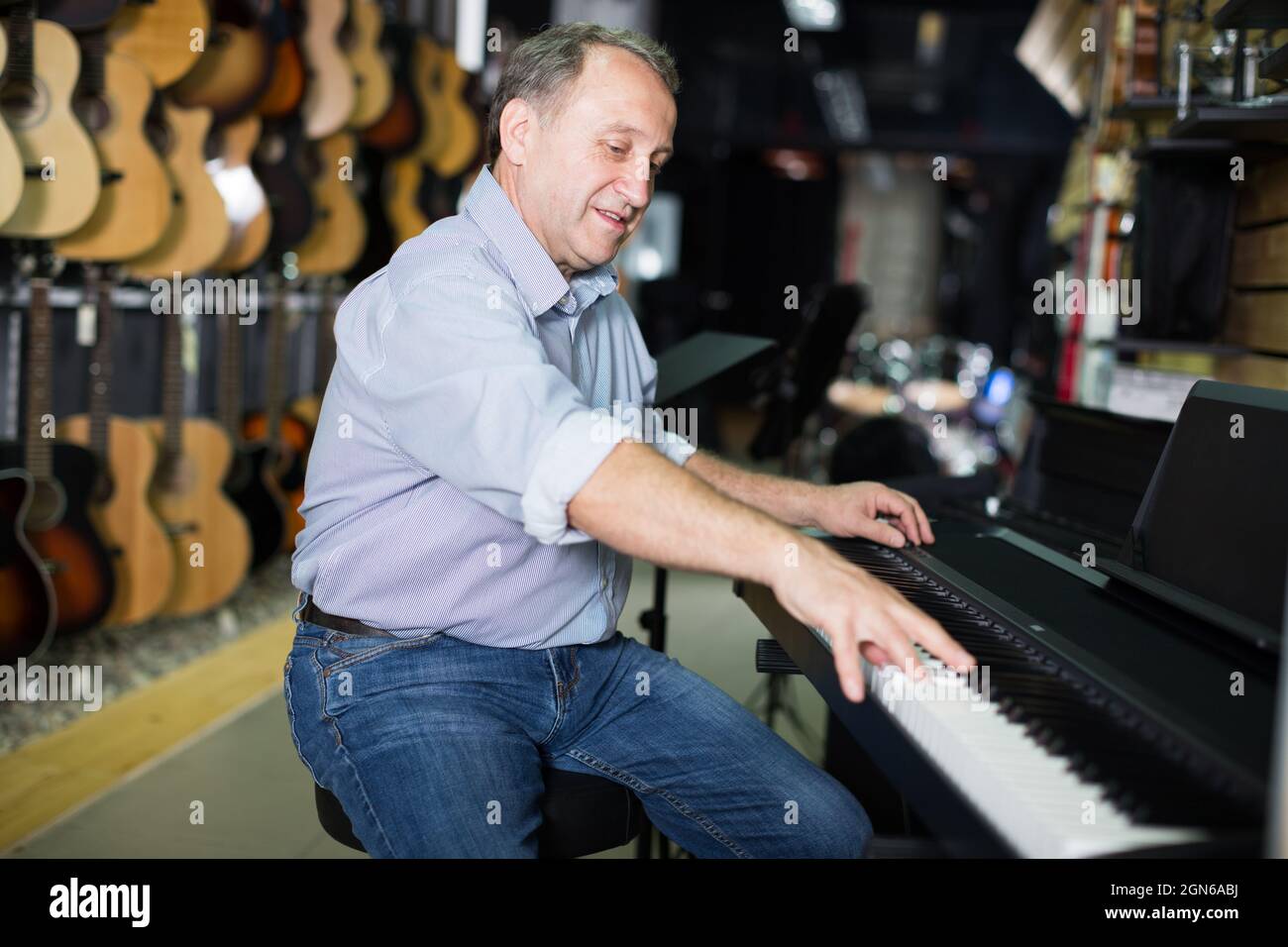 Musician male is choosing keyboard and playing on it Stock Photo - Alamy