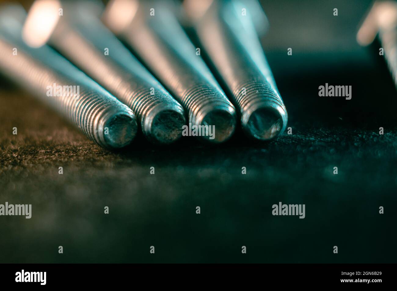 Closeup of the metal silver bolts on the black surface Stock Photo - Alamy