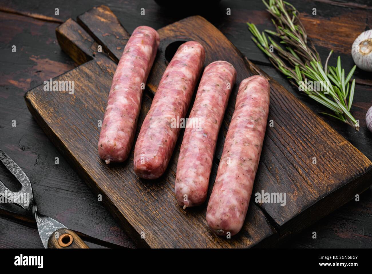 Raw Sausages with Herbs and Spices set, on old dark wooden table ...