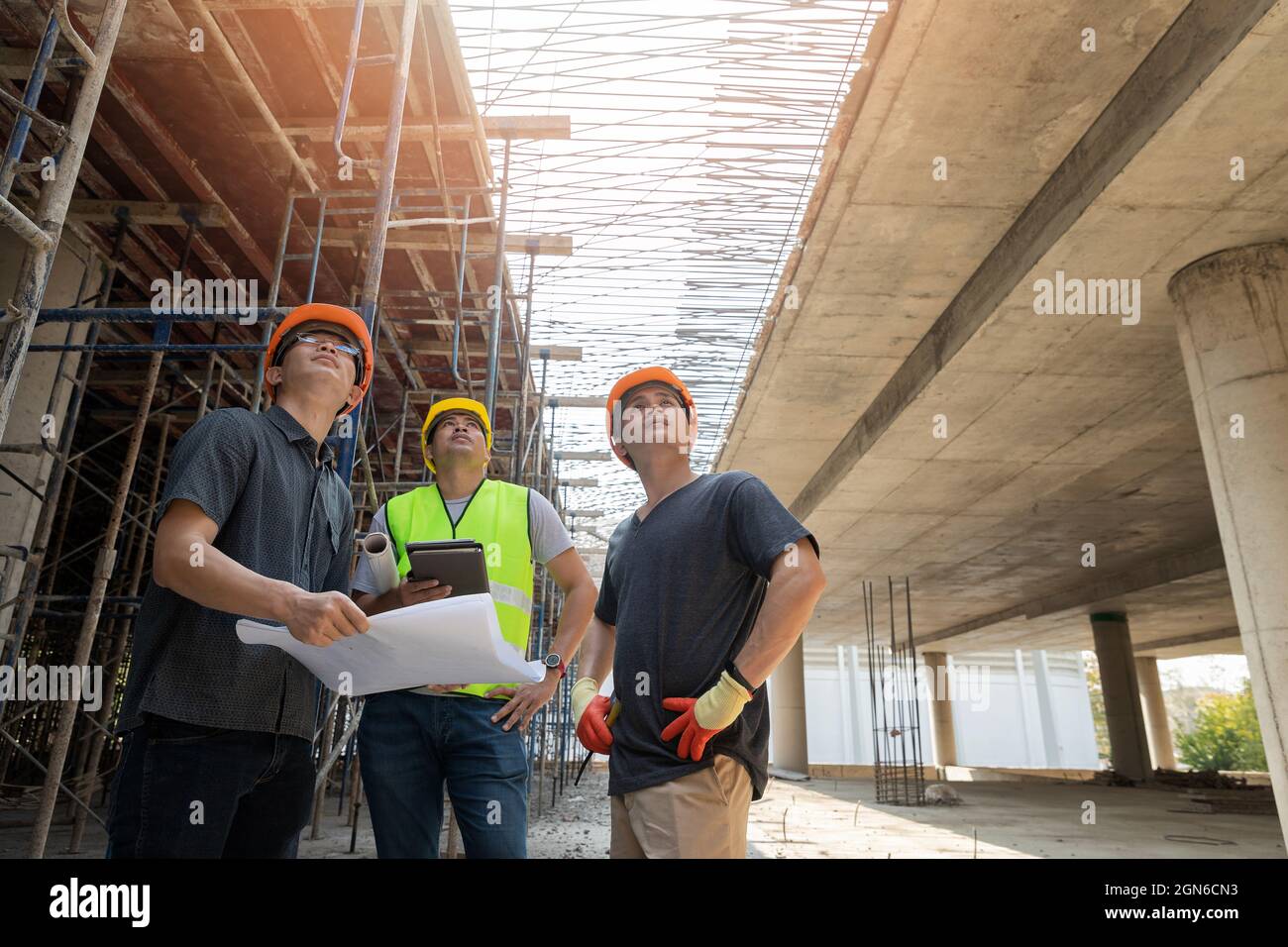 Team of construction workers discussing project details with executive ...