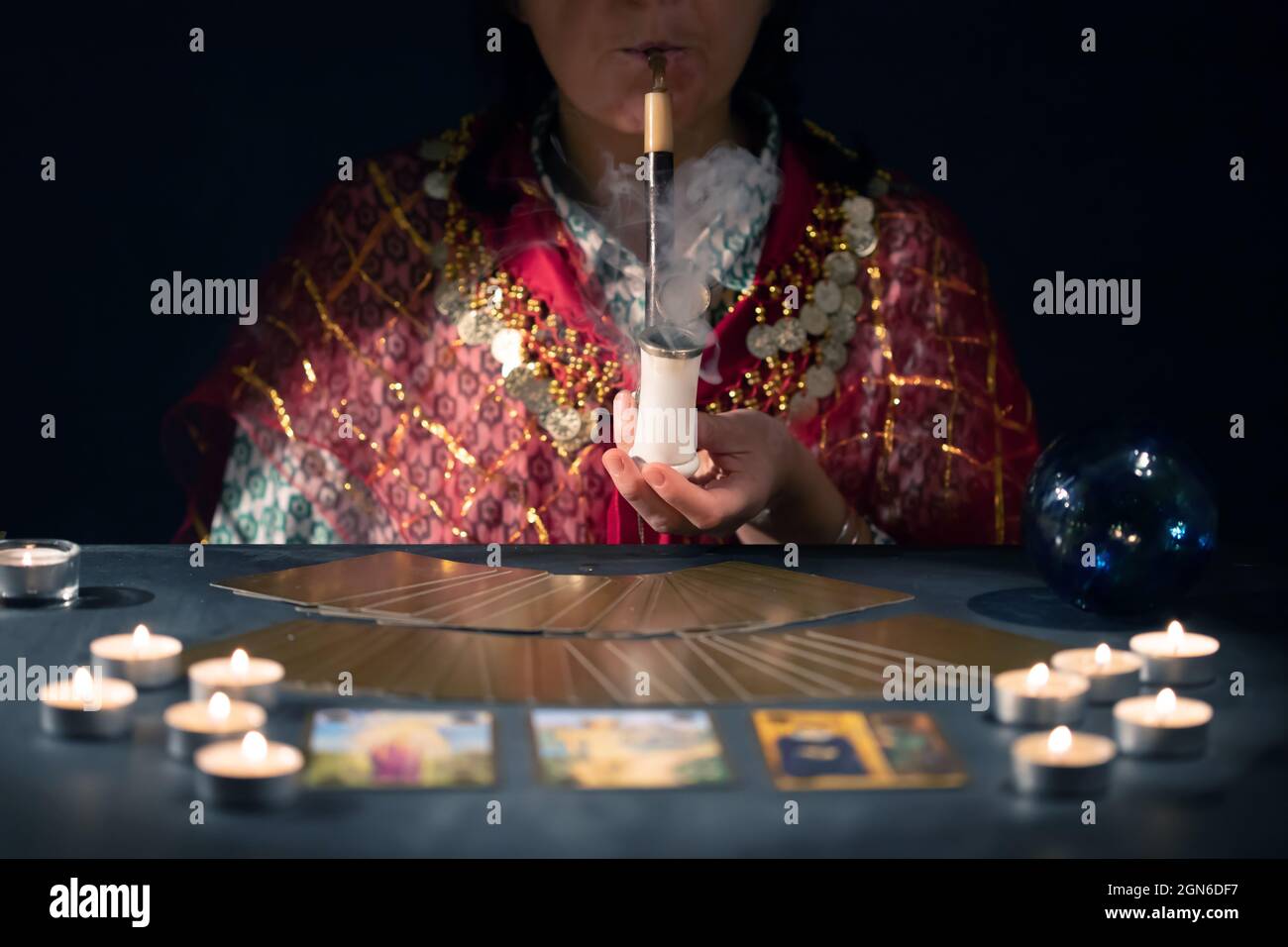 Fortune teller with tarot cards on table near burning candles.Tarot ...
