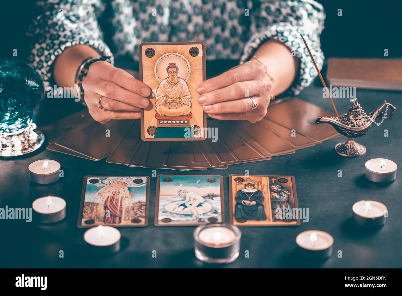 Fortune teller with tarot cards on table near burning candles.Tarot ...