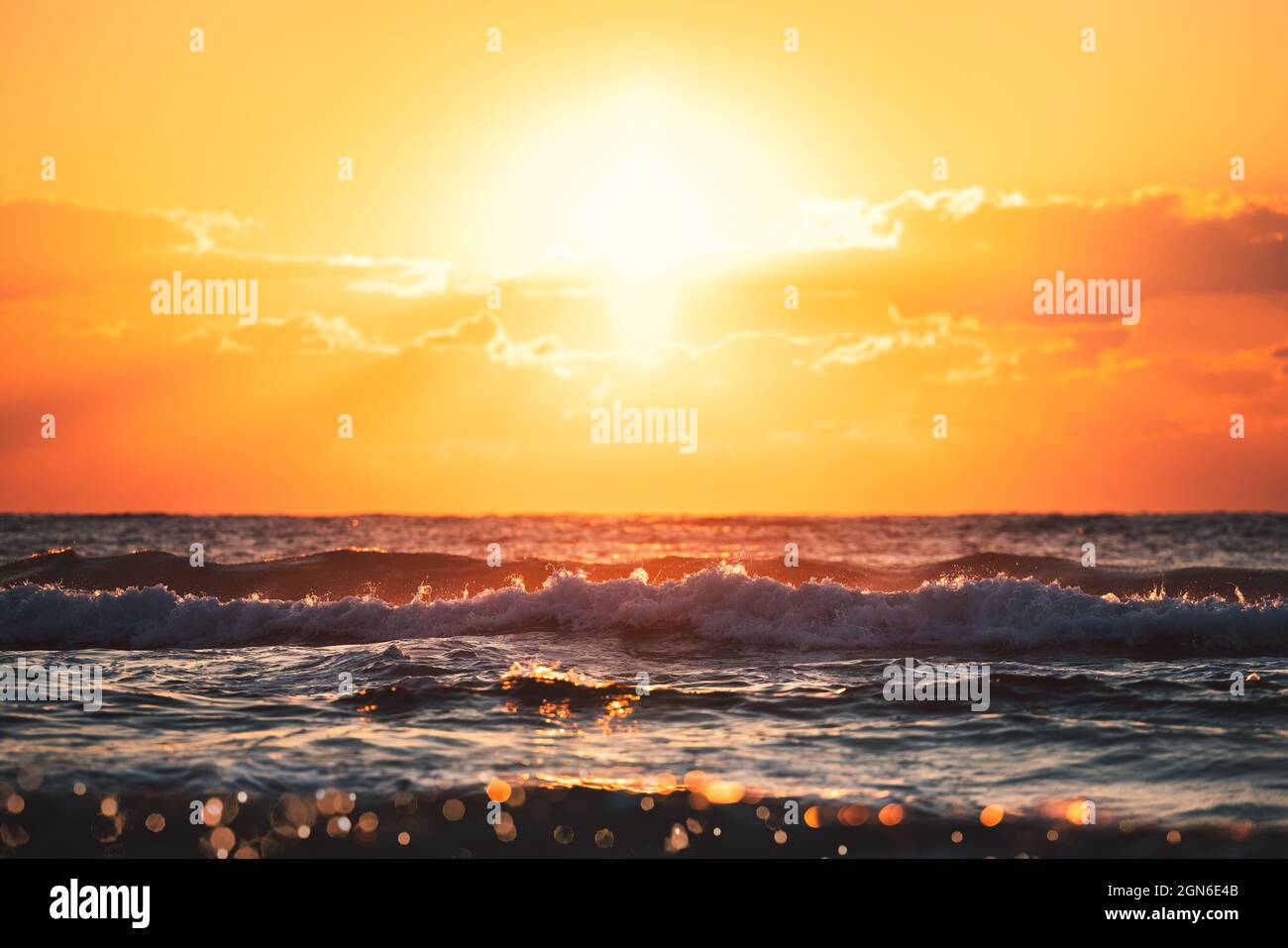 Splashing wave and sunrise beach Stock Photo - Alamy