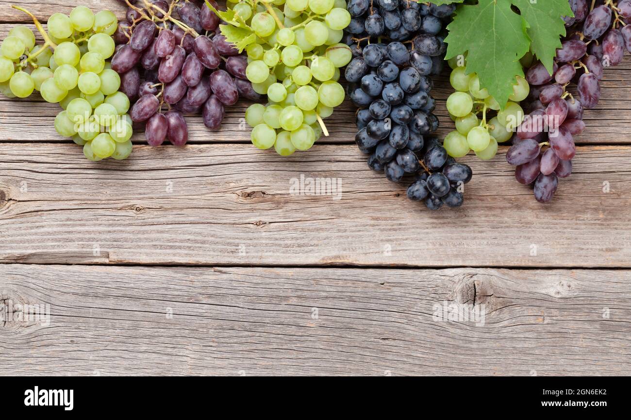 Various colorful grapes on wooden table. Top view flat lay with copy ...