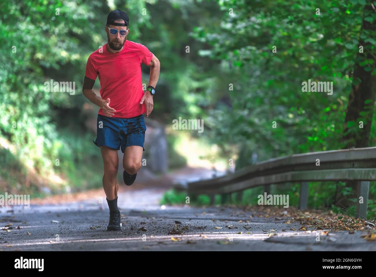 An athlete running on an uphill asphalt road Stock Photo - Alamy