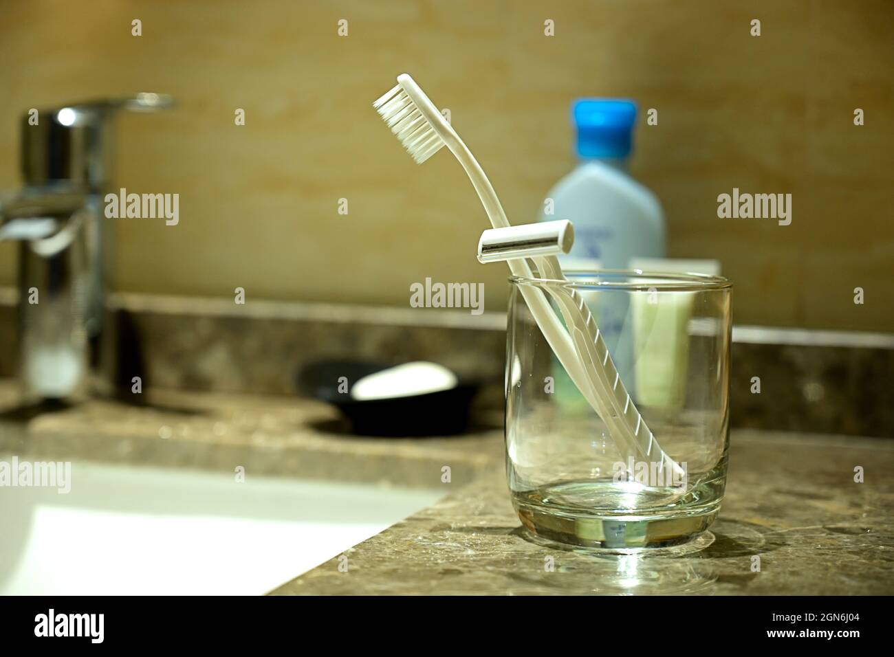 Glass with razor, toothbrush on the table in a bathroom Stock Photo - Alamy