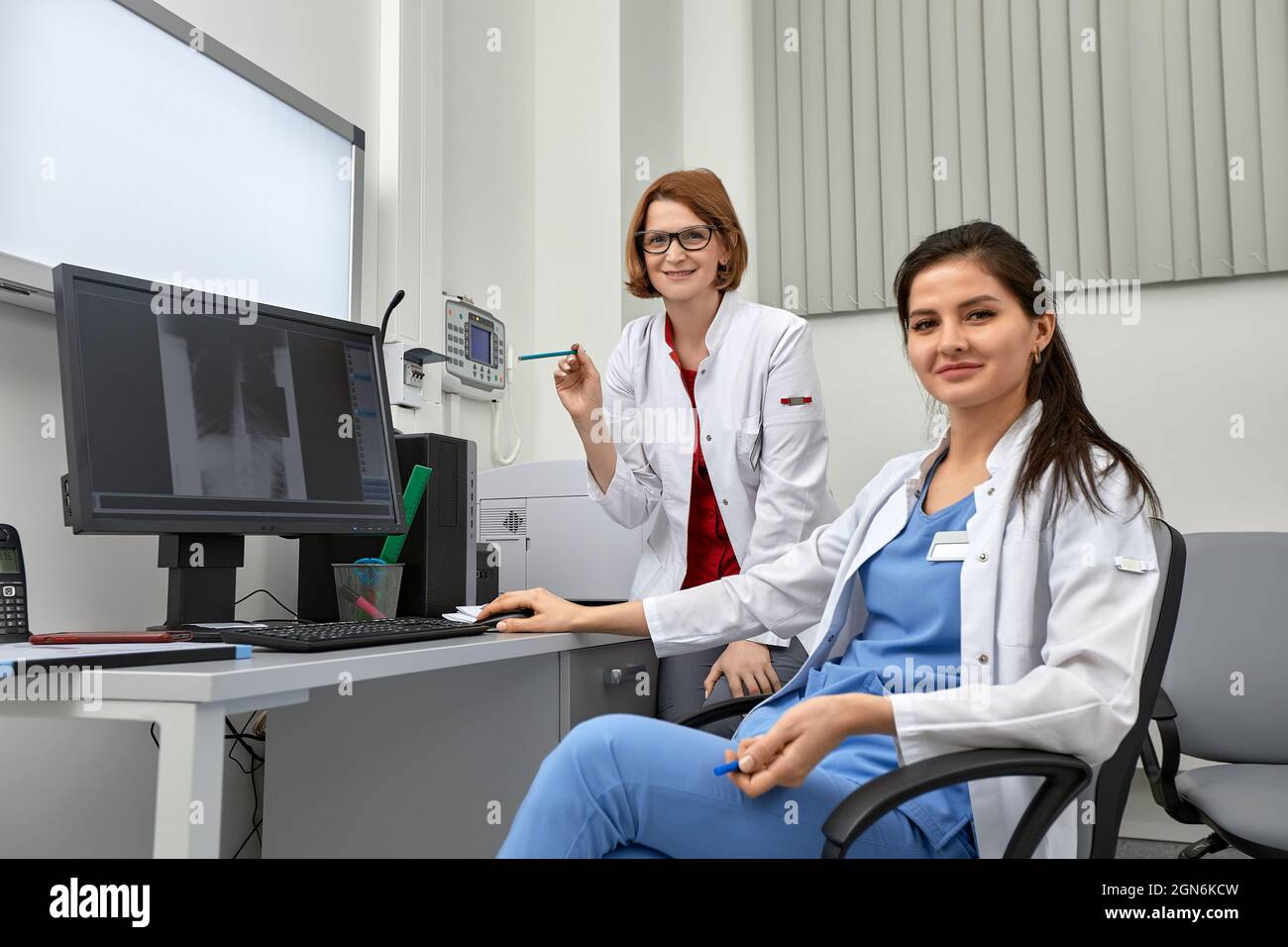 medical team discussing around a computer Stock Photo - Alamy