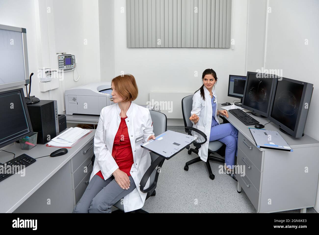 medical team discussing around a computer Stock Photo - Alamy
