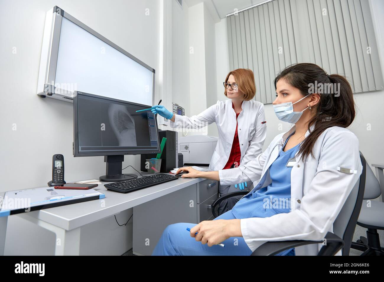 medical team discussing around a computer Stock Photo - Alamy