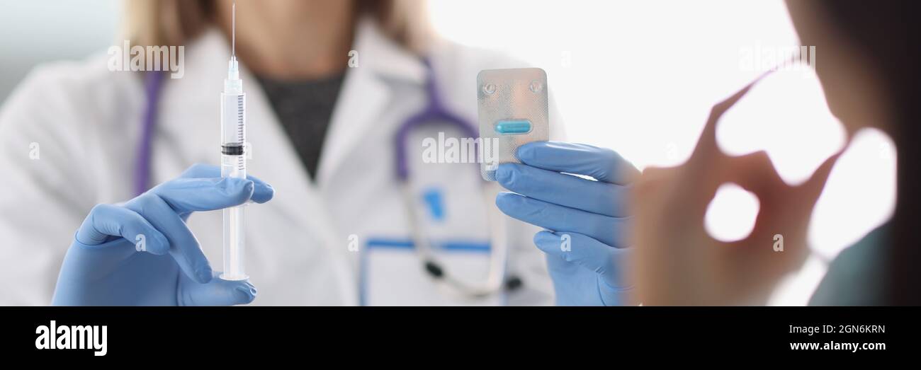 Doctor offers patient choice of an injection or pill Stock Photo - Alamy