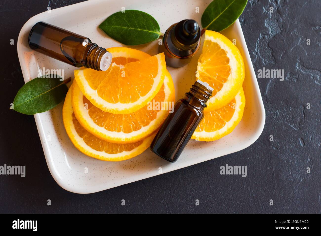 essential aromatic oil of orange with citrus on a ceramic tray and ...
