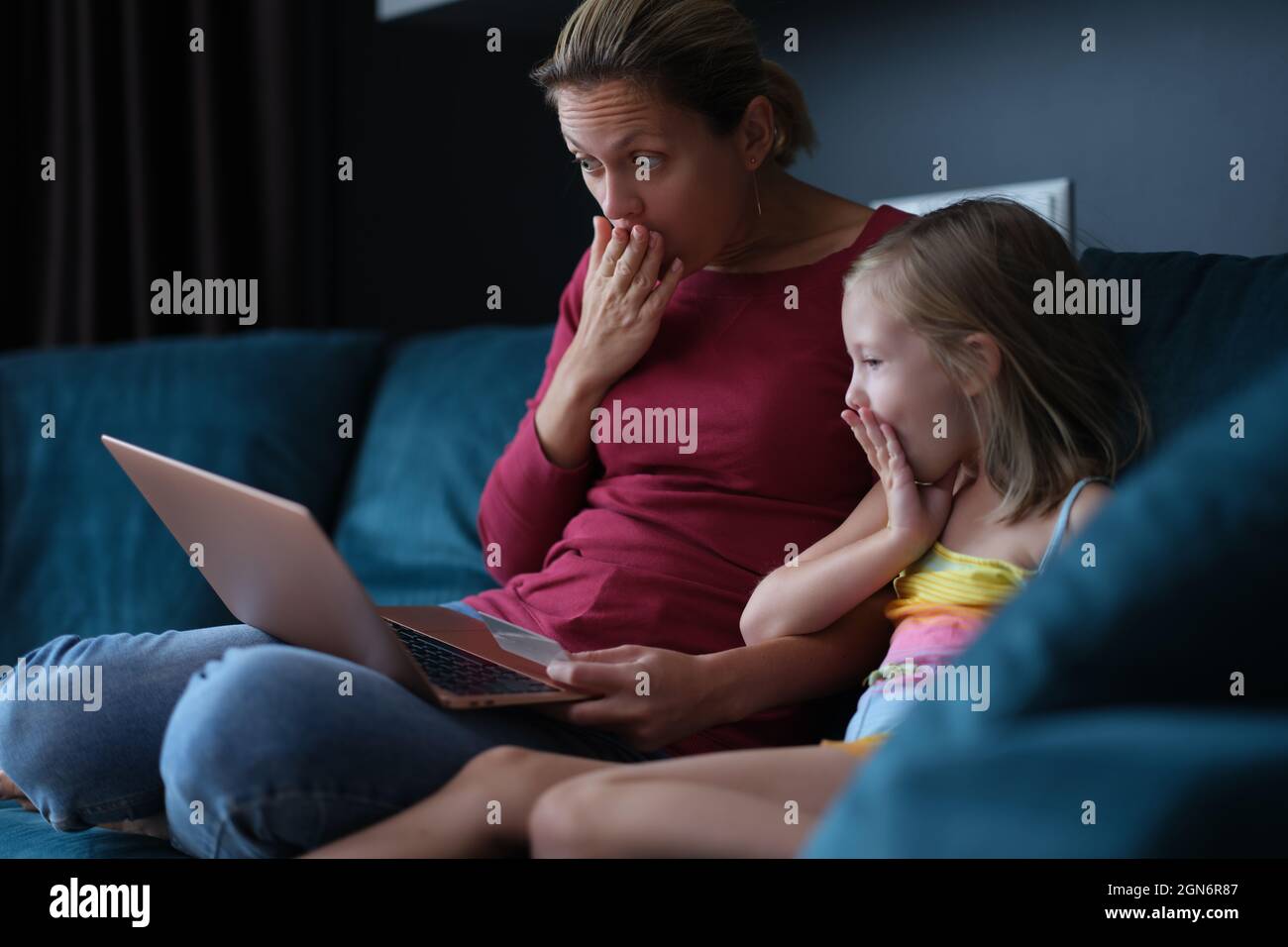 Shocked surprised mom and daughter looking at laptop screen while ...