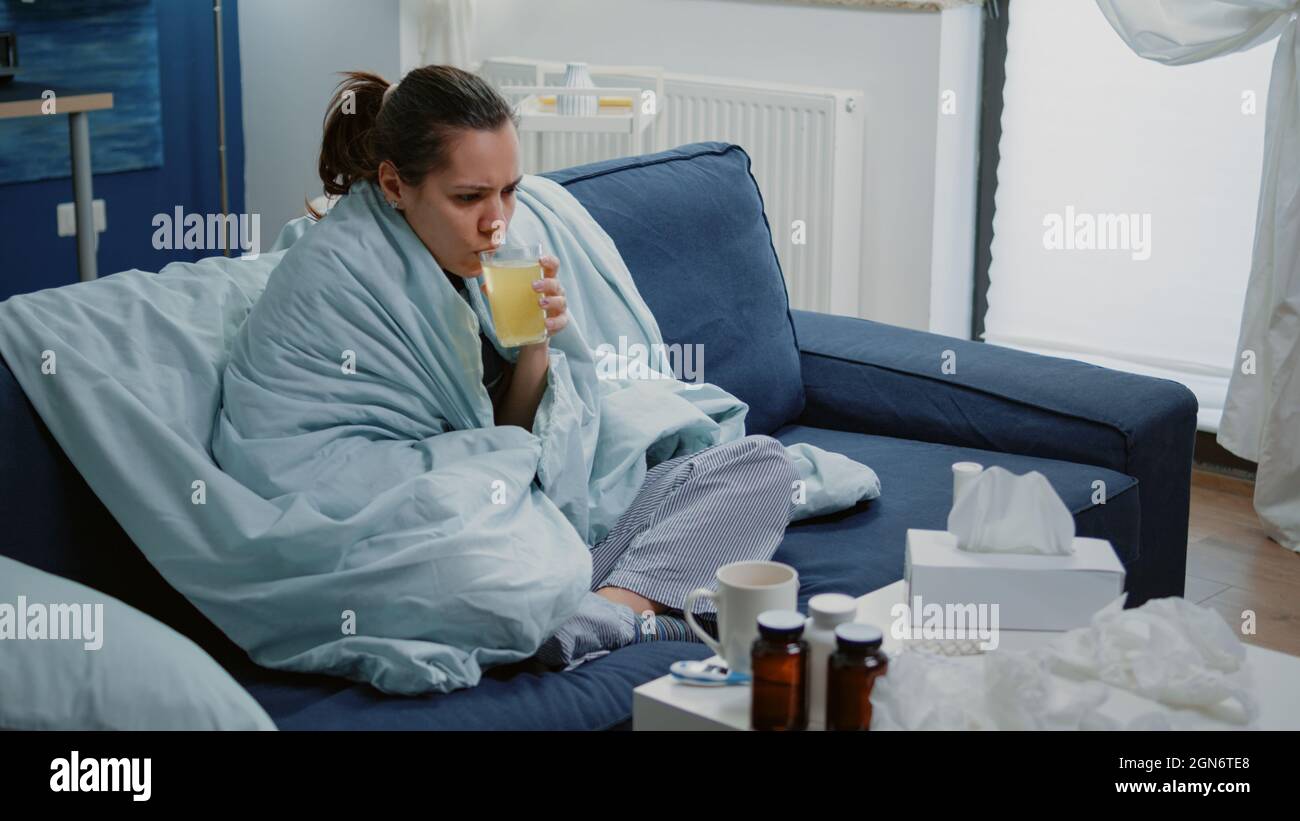 Woman with flu drinking effervescent medication with water to cure cold ...