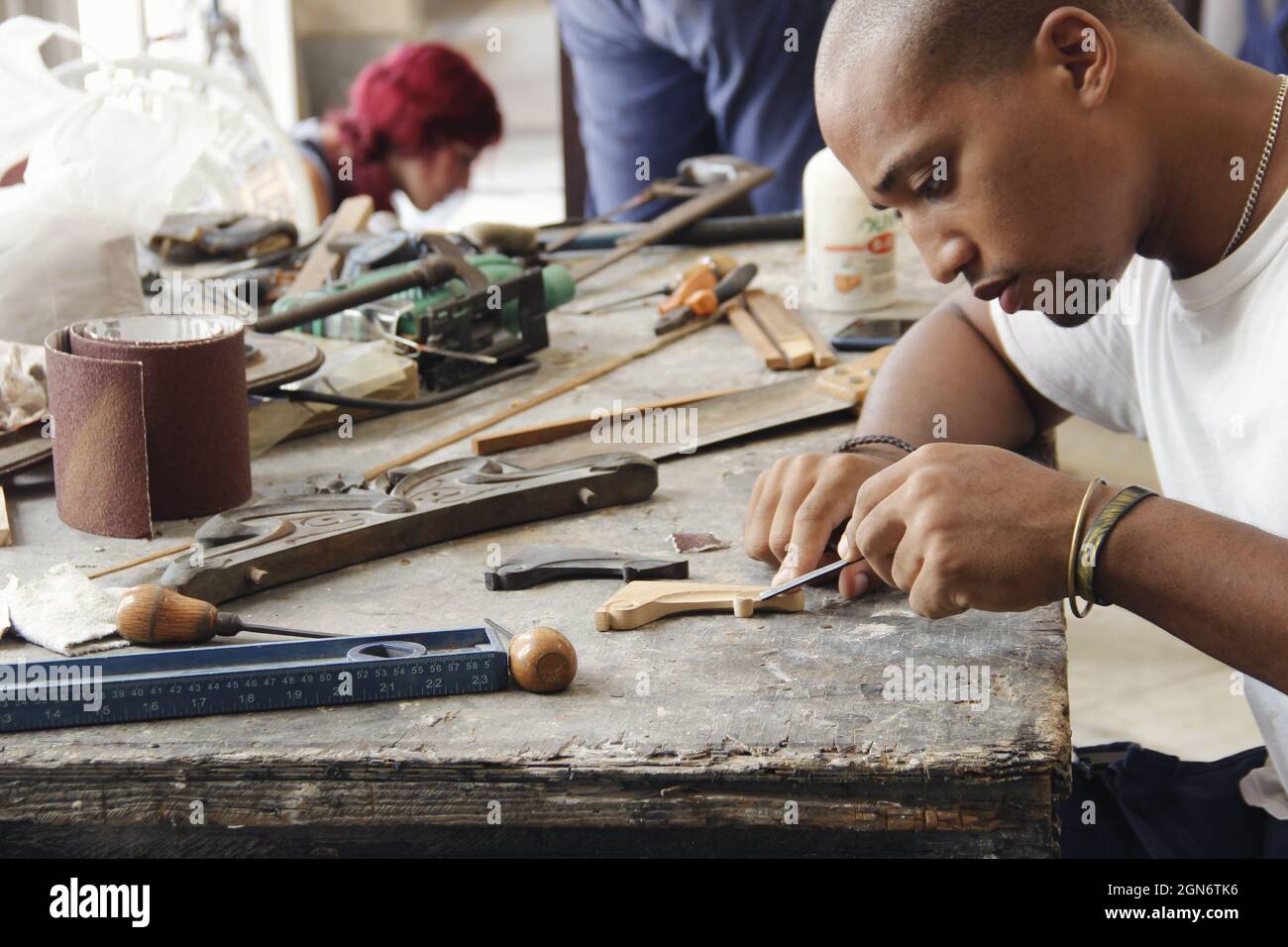 Young man crafting wood on a table Stock Photo - Alamy