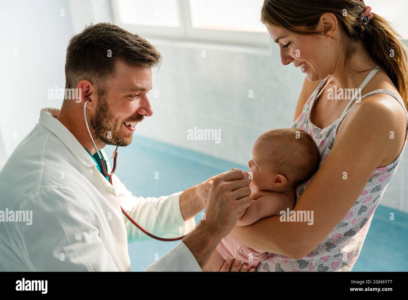 Happy pediatrician doctor with baby checking possible heart defect ...
