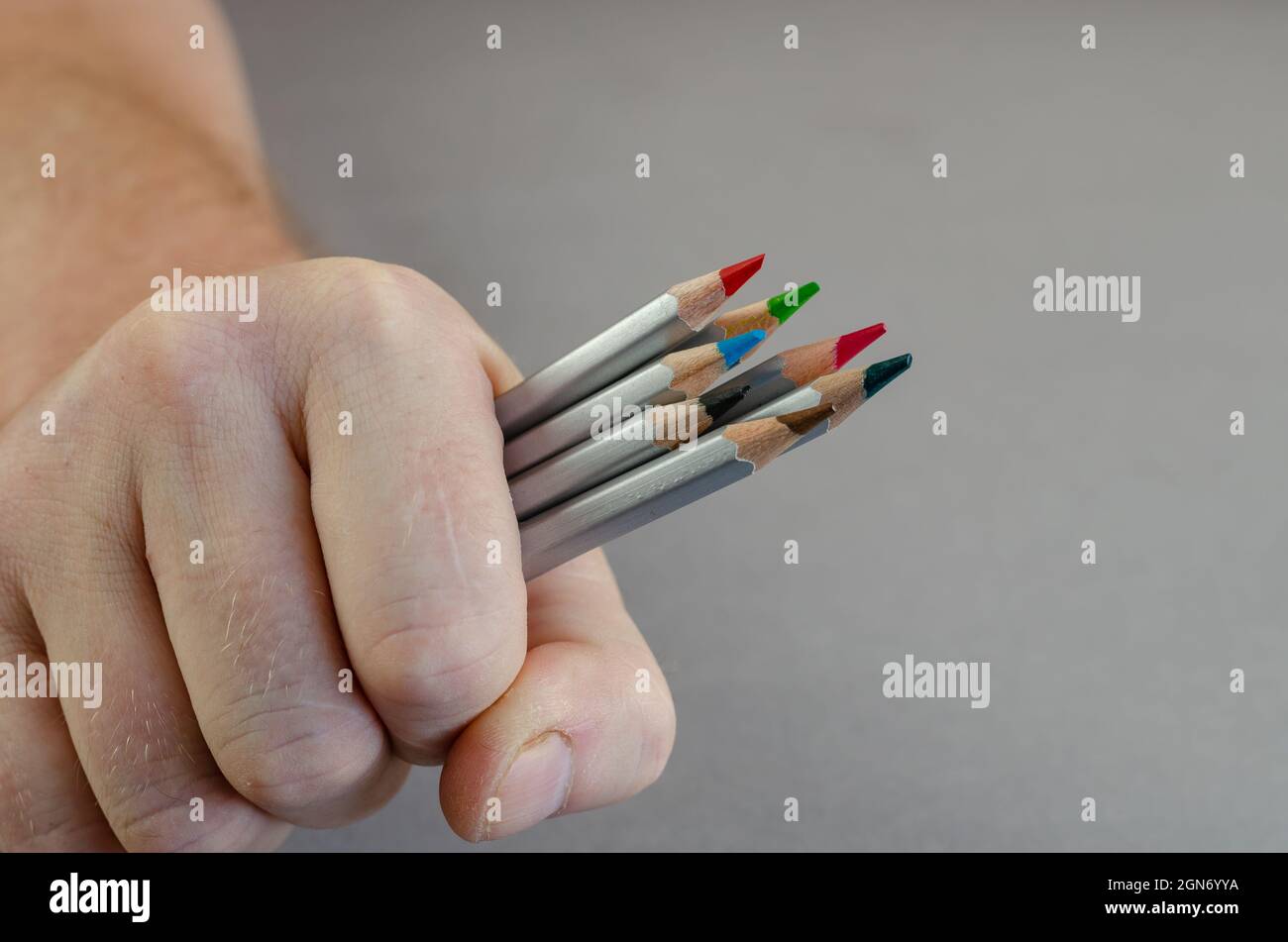 An adult male holding multicolored pencils. A hand and a set of Stock ...