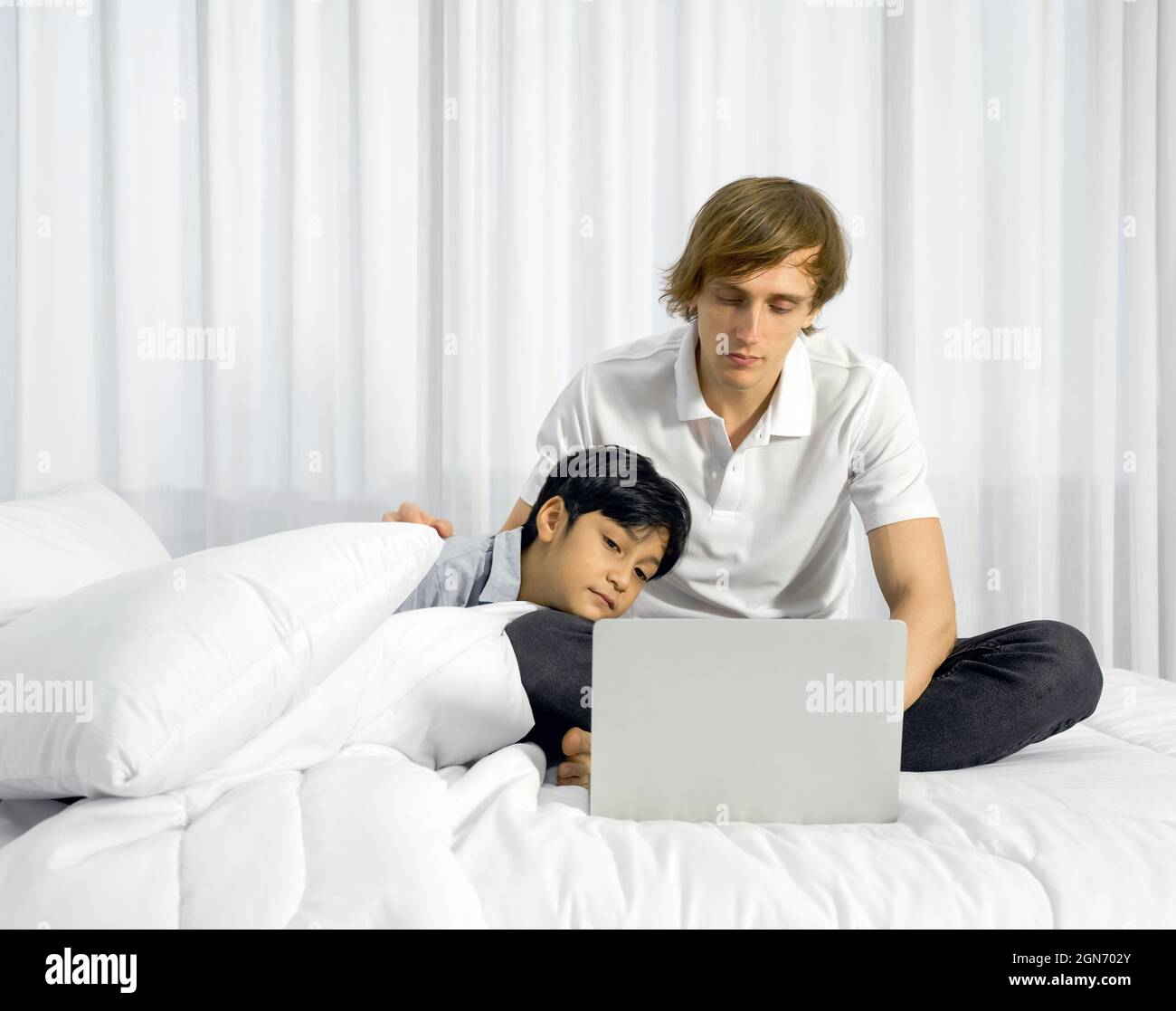 Father work at home with son. A boy napping on his father's lap while ...