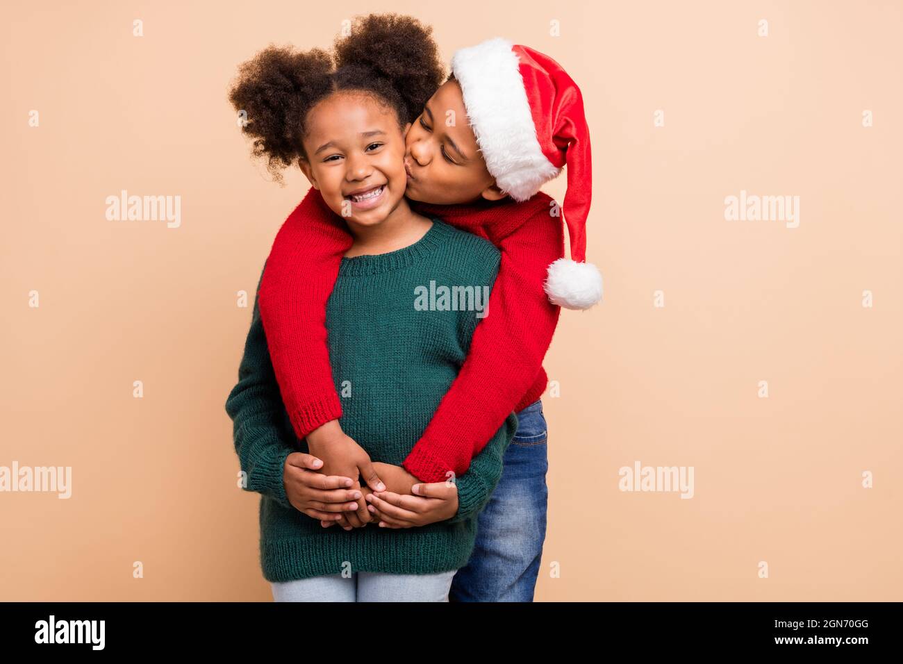 Photo of two romantic affectionate kids boy kiss girl cuddle wear x-mas ...
