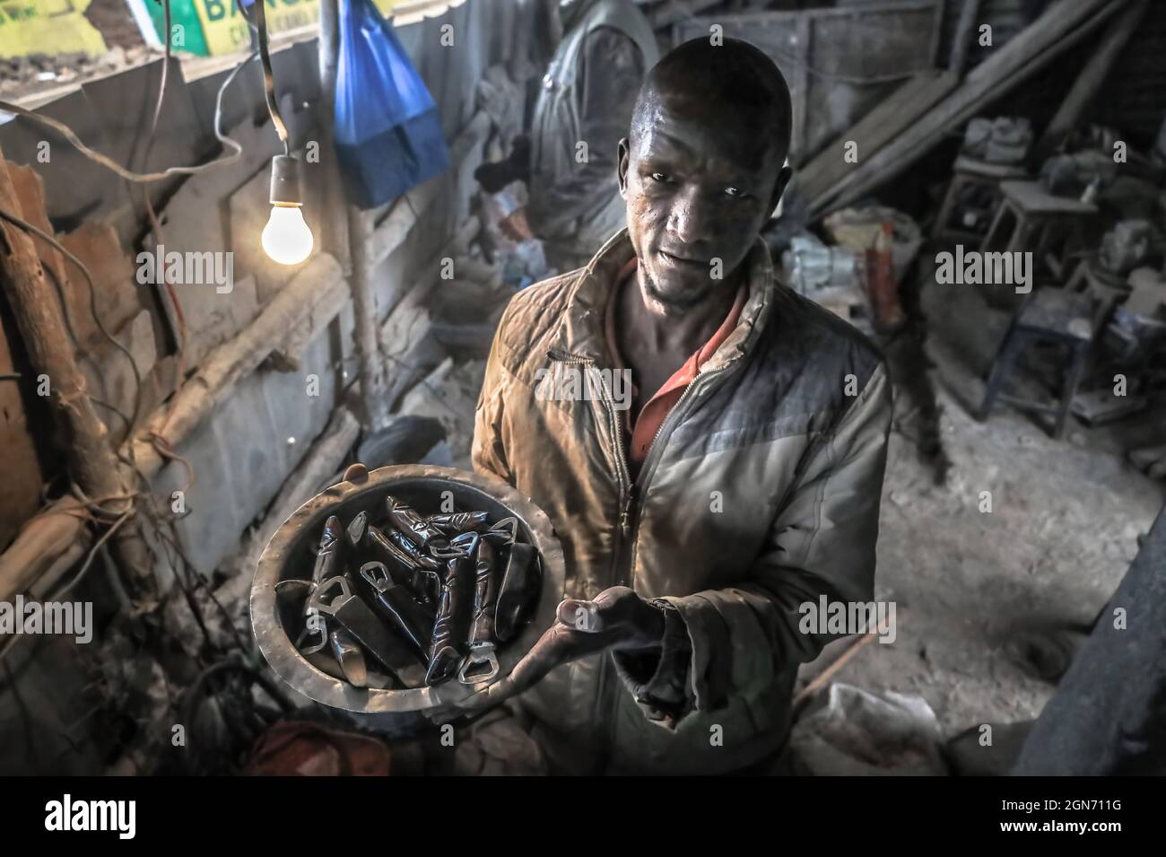 Victor Otieno (36) holds a bowl full of handmade keyholders made from ...