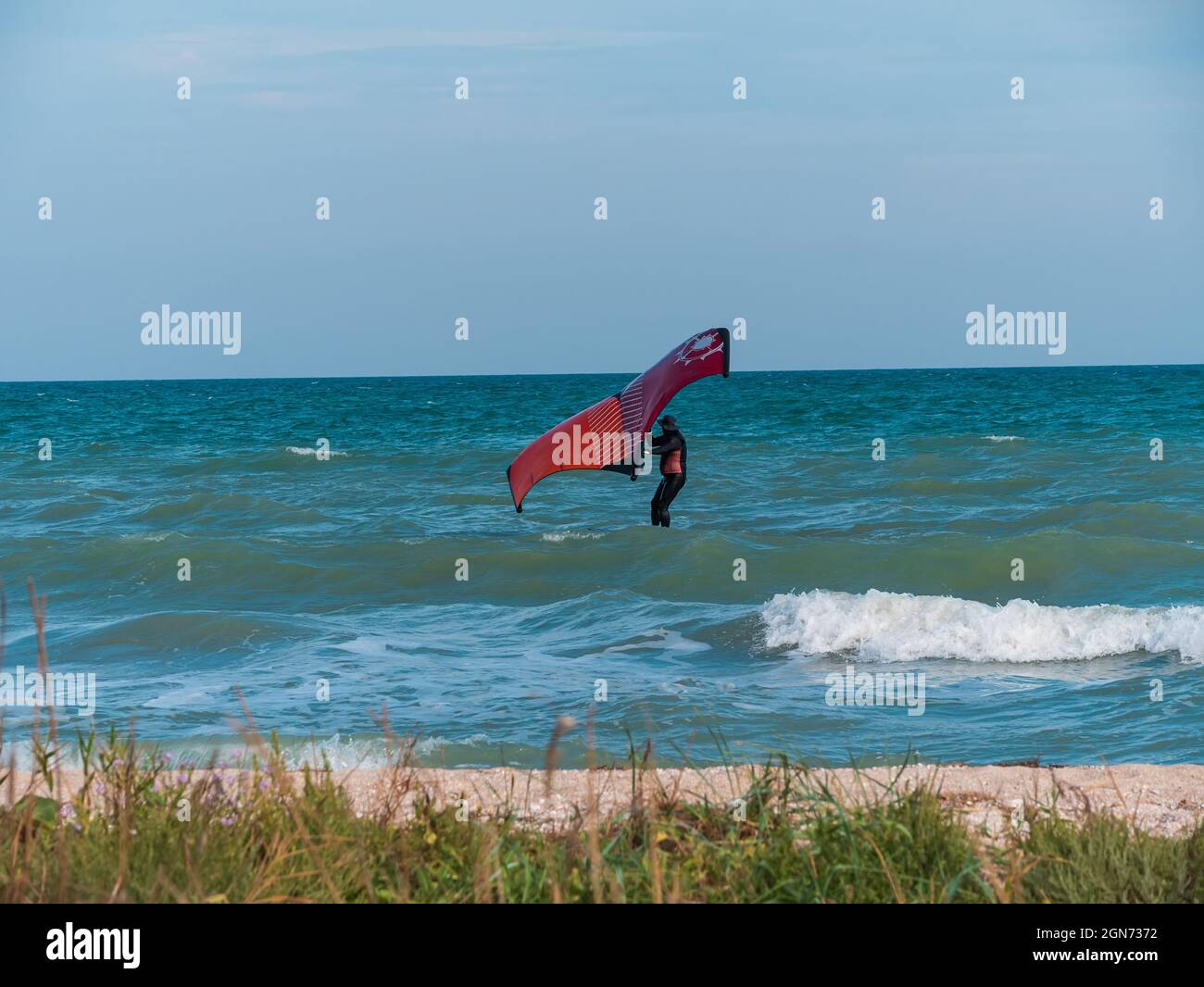 The athlete riding a hydrofoil surfboard using a hand held foil wing on ...