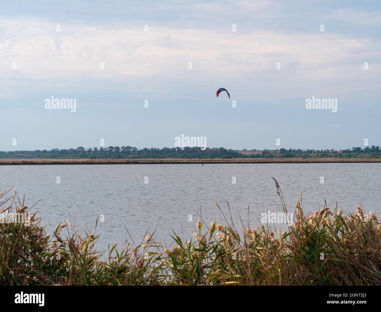 The athlete practices kite board surfing on blue sea waves. Autumn ...
