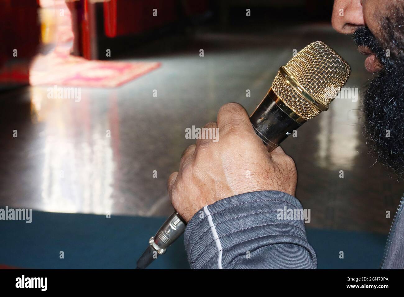 golden colored Professional Portable Condenser microphone on hand the ...